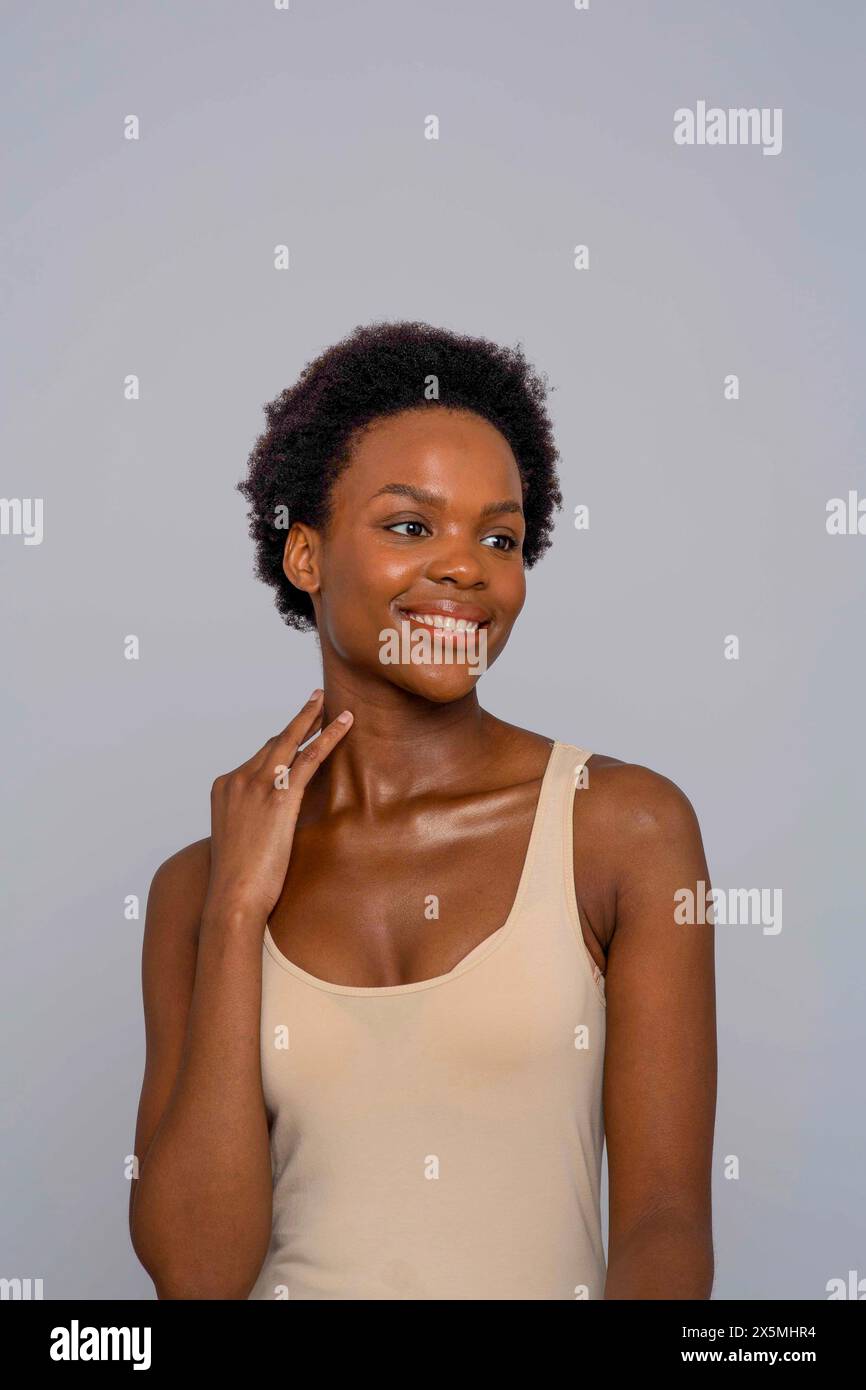 Studio portrait of smiling woman in cream colored tank top Stock Photo ...