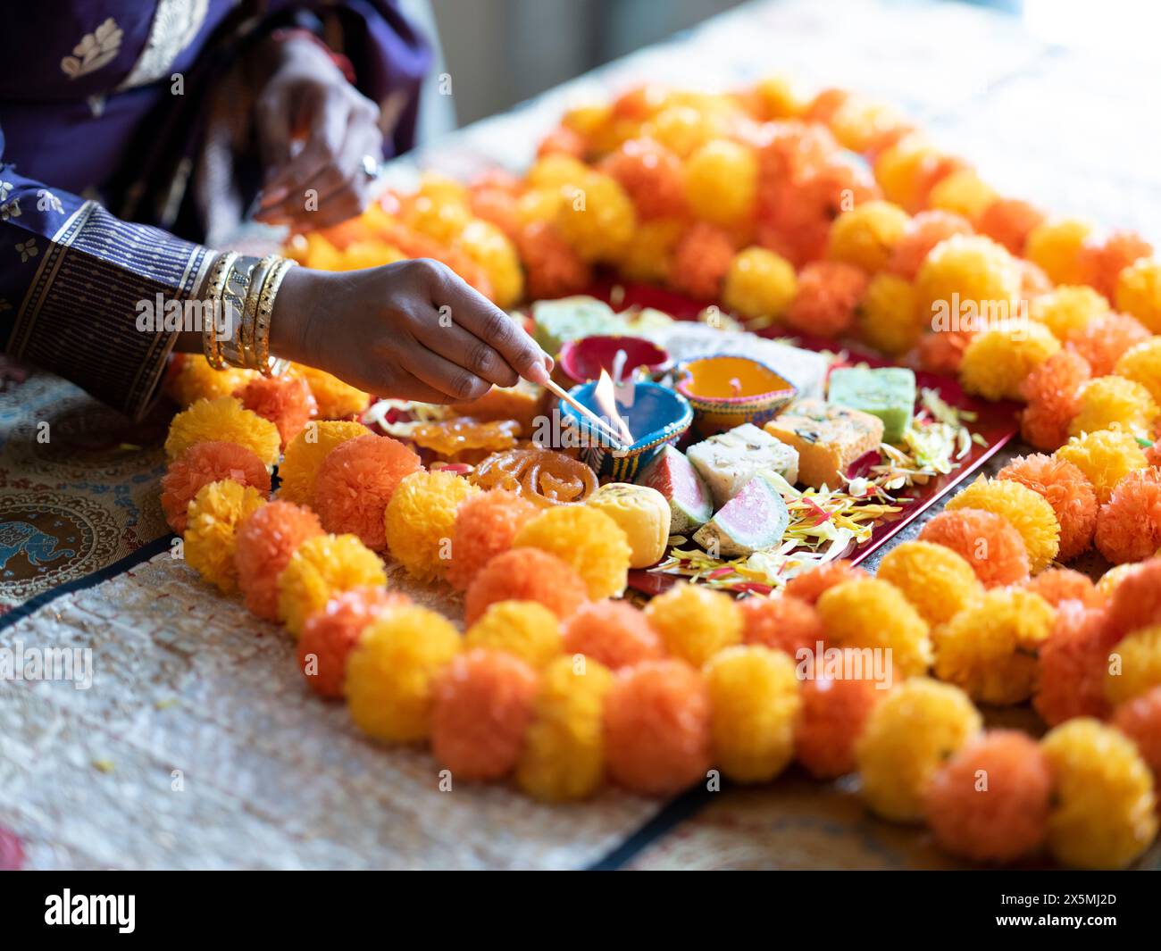 Woman lighting diyas on Diwali sweets platter Stock Photo - Alamy