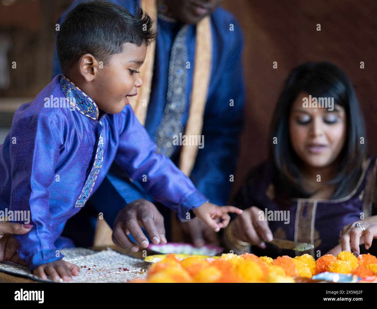 Parents and son eating Diwali snacks Stock Photo - Alamy