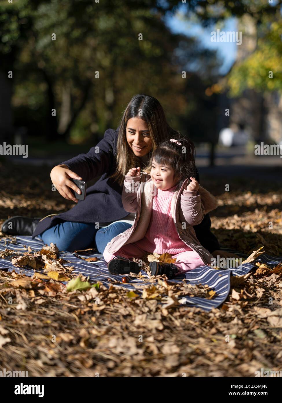 Mother and daughter with Down syndrome taking selfie in park Stock ...