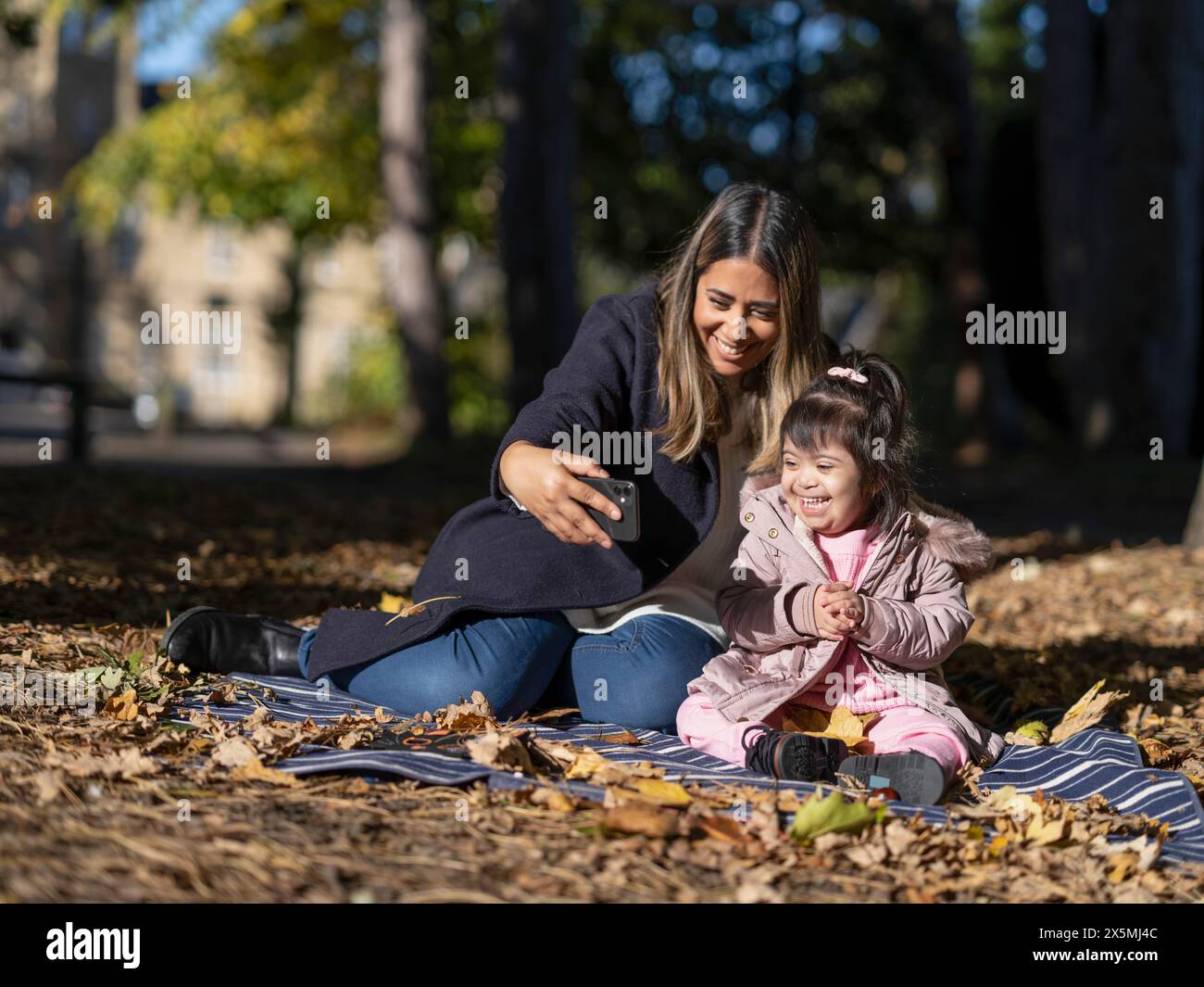 Mother and daughter with Down syndrome taking selfie in park Stock ...