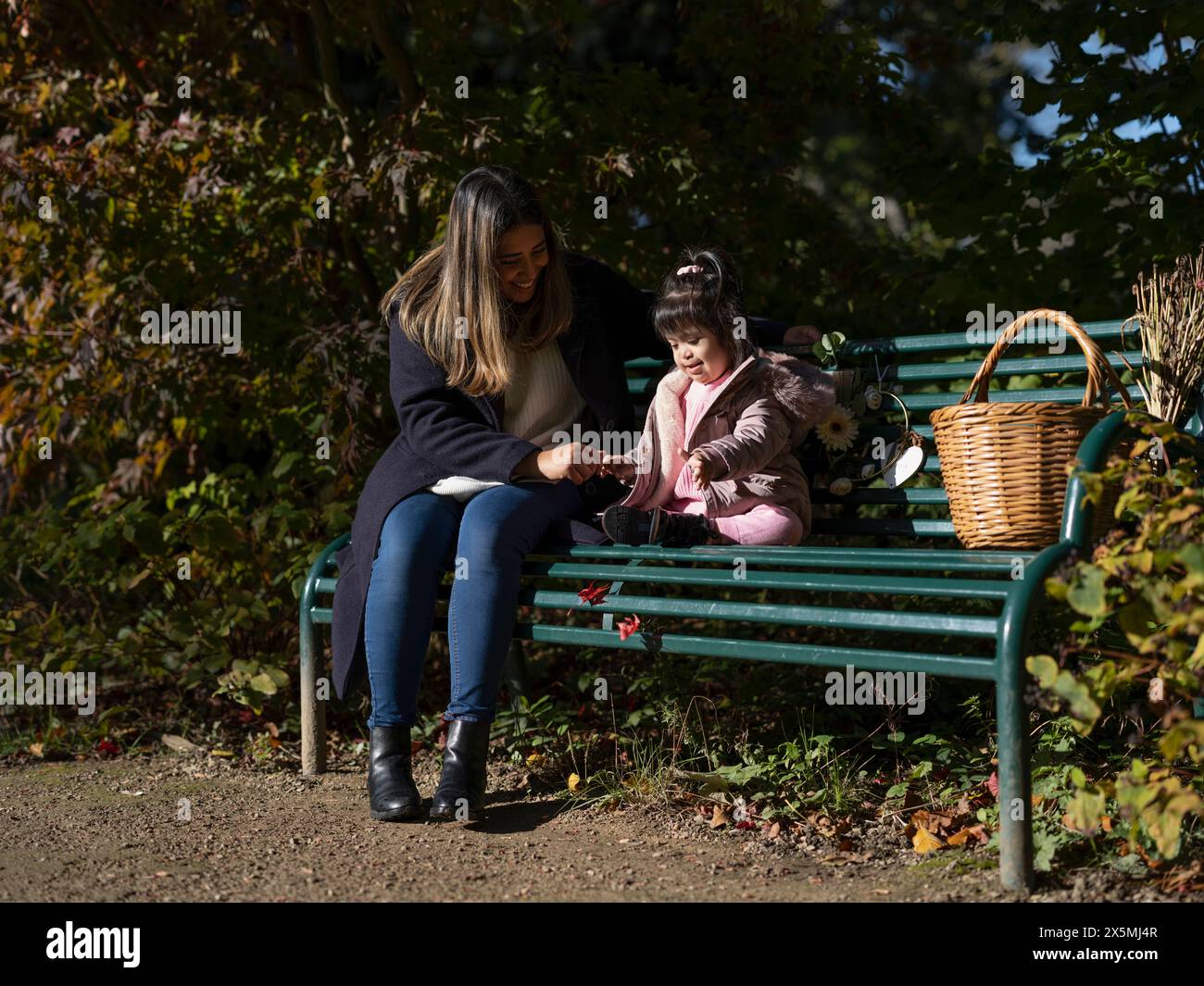 Mother and daughter with Down syndrome sitting on bench Stock Photo - Alamy