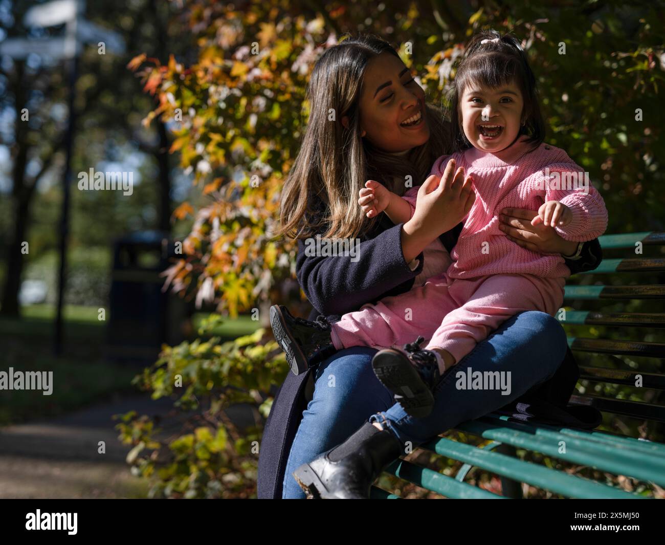 Mother and daughter with Down syndrome sitting on bench Stock Photo - Alamy