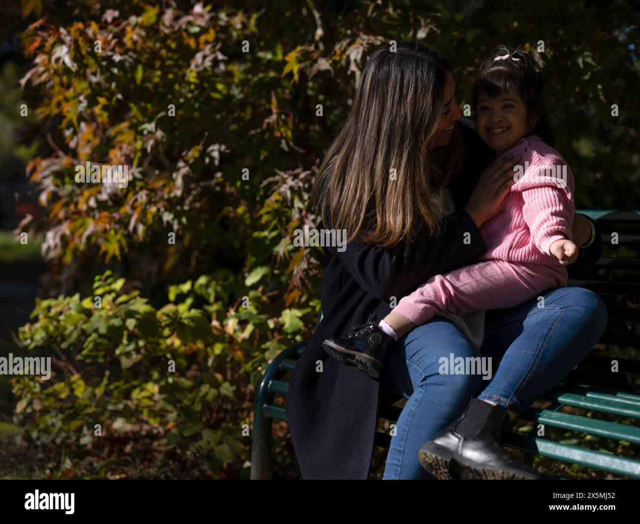 Mother and daughter with Down syndrome hugging on bench Stock Photo - Alamy
