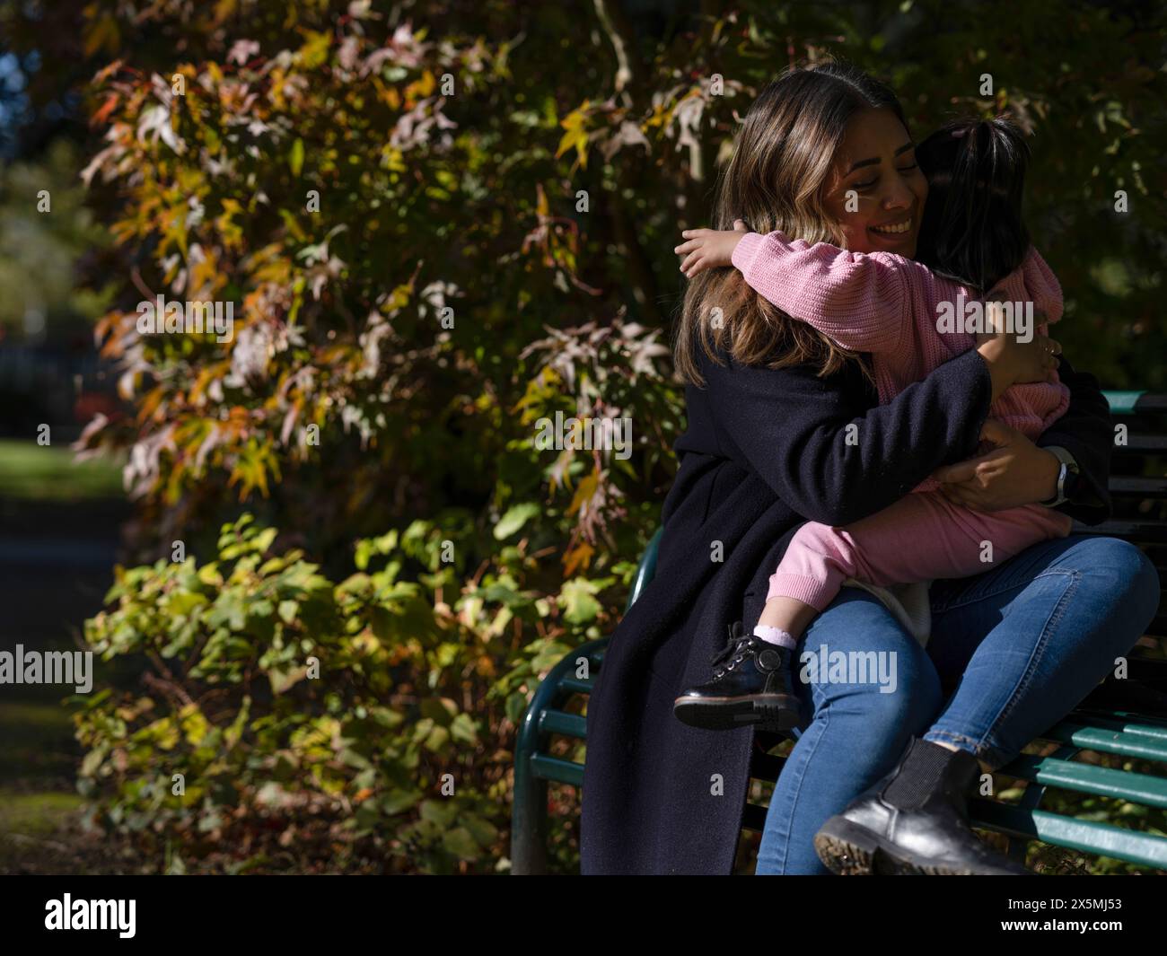 Mother and daughter with Down syndrome hugging on bench Stock Photo - Alamy