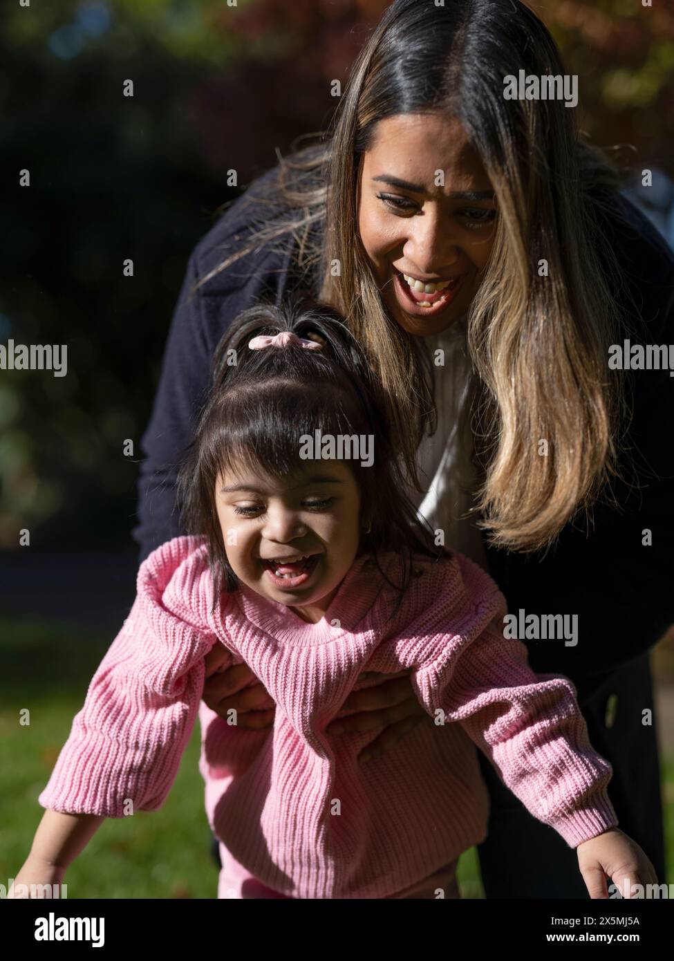 Mother and daughter with Down syndrome walking in park Stock Photo - Alamy