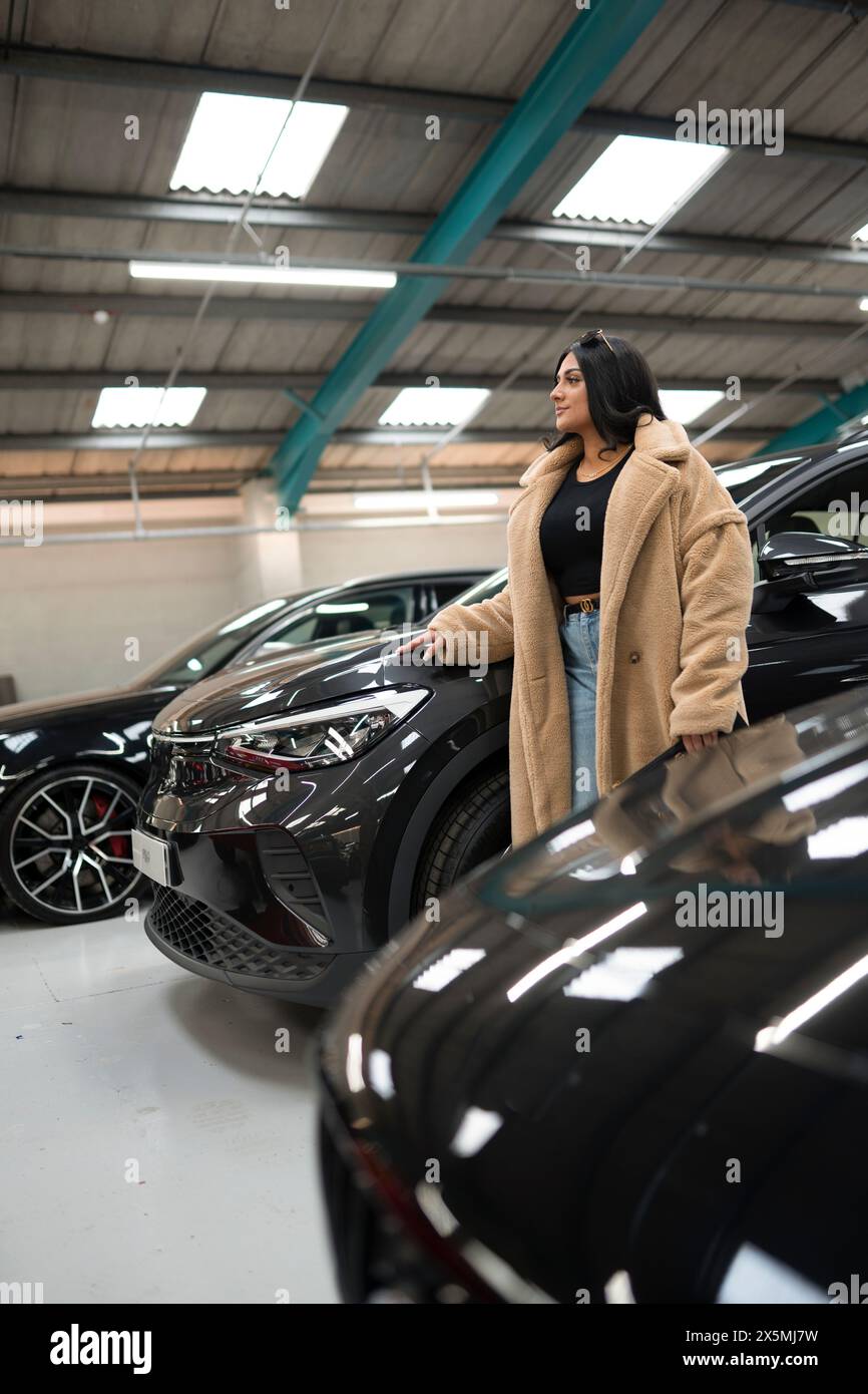Young woman standing among luxury cars Stock Photo - Alamy