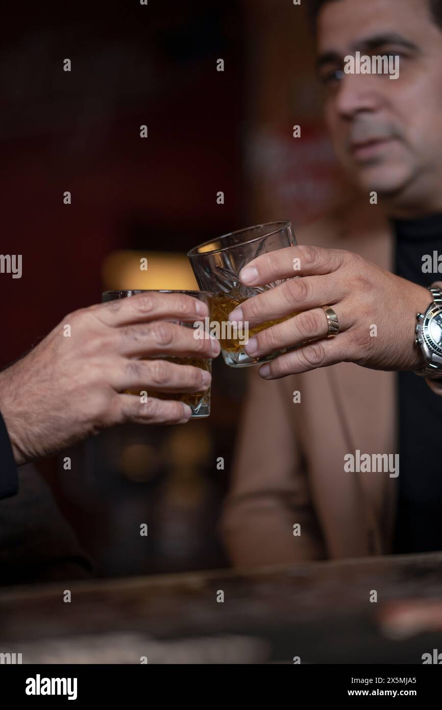 Men raising toast with drinks Stock Photo - Alamy
