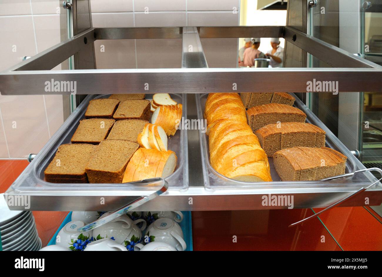 Tray with fresh bread and buns placed on a canteen counter Stock Photo ...