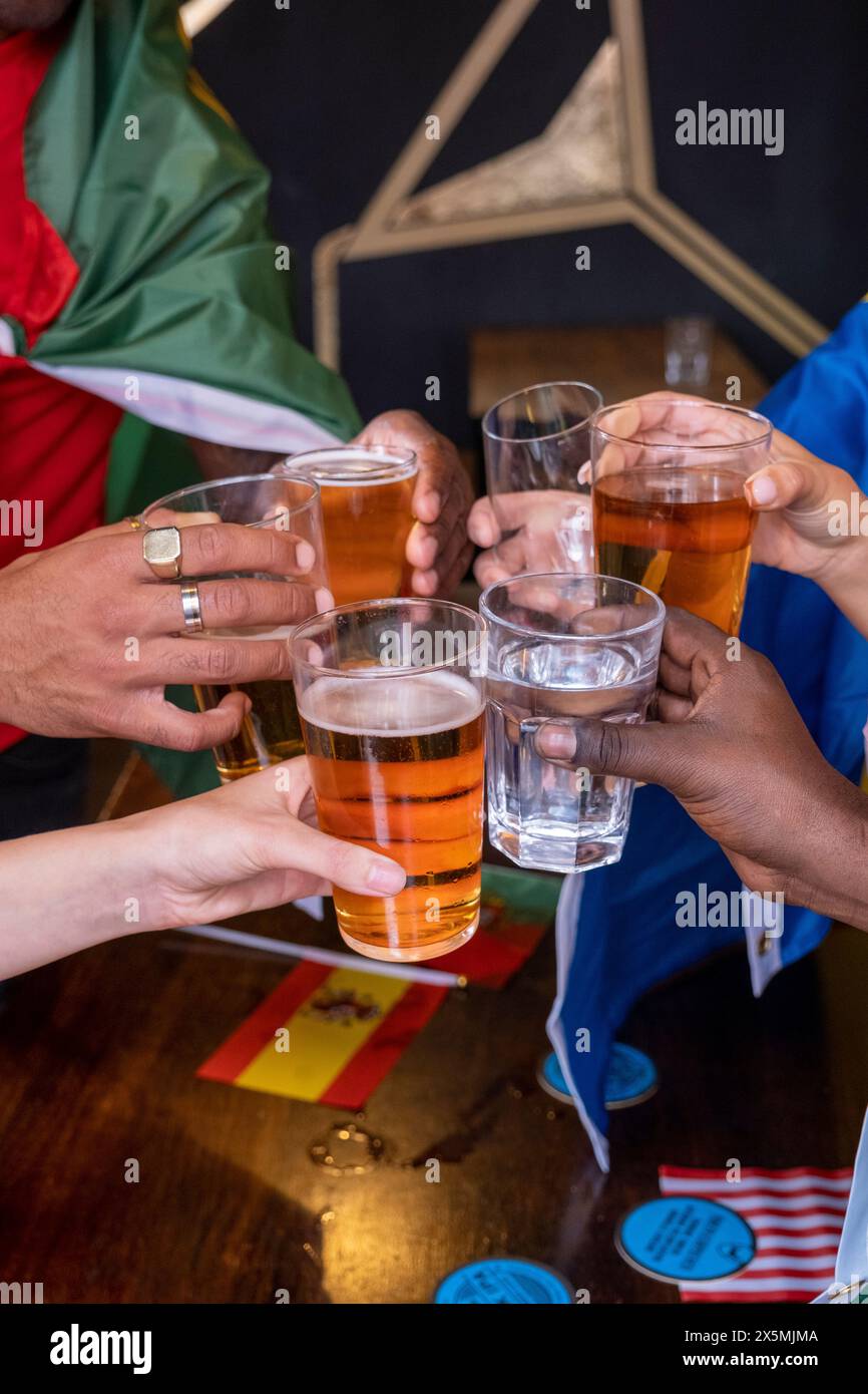 Friends dressed in national flags for world cup competition drinking ...