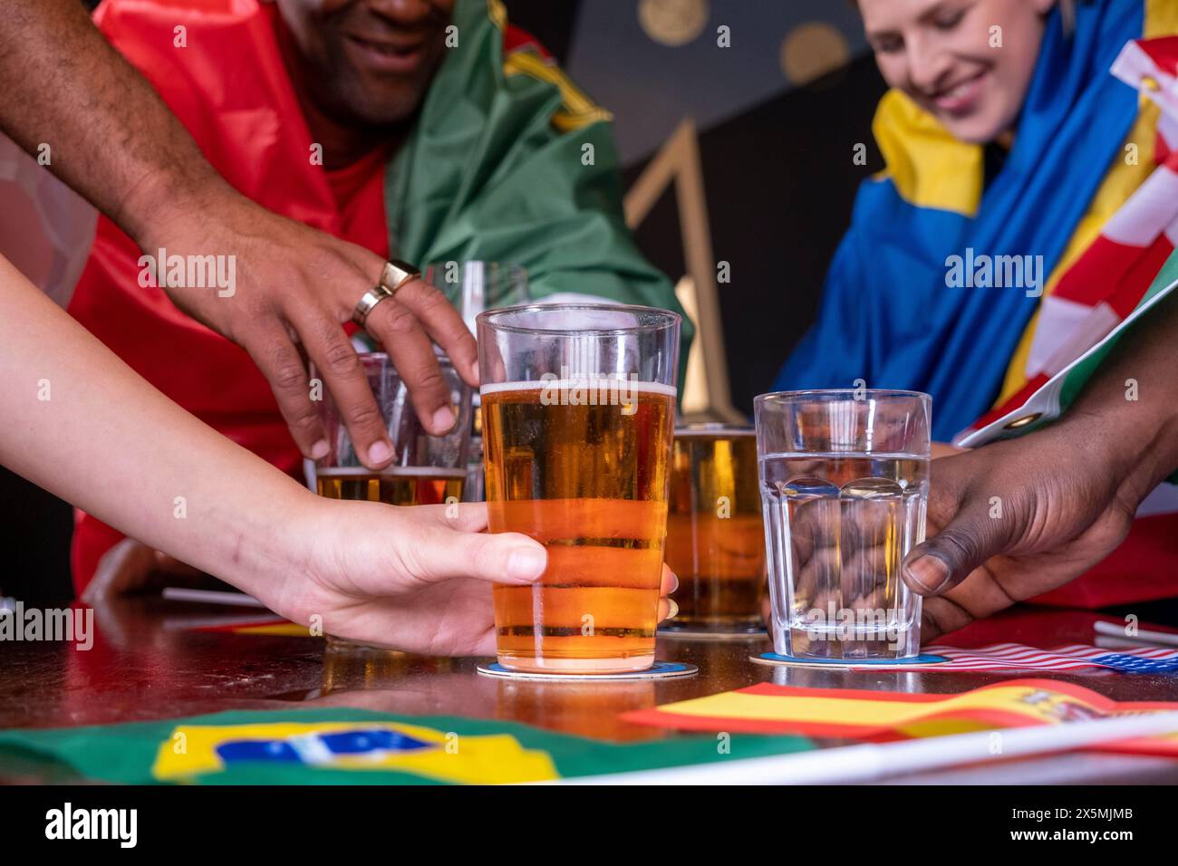 Friends dressed in national flags for world cup competition drinking ...