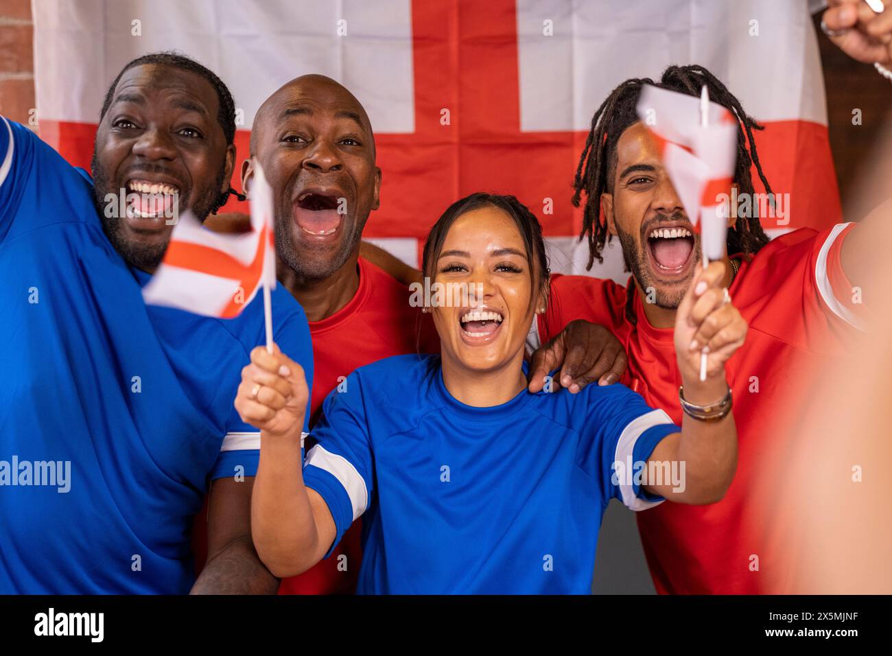 Friends waving national flags during world cup competition Stock Photo ...