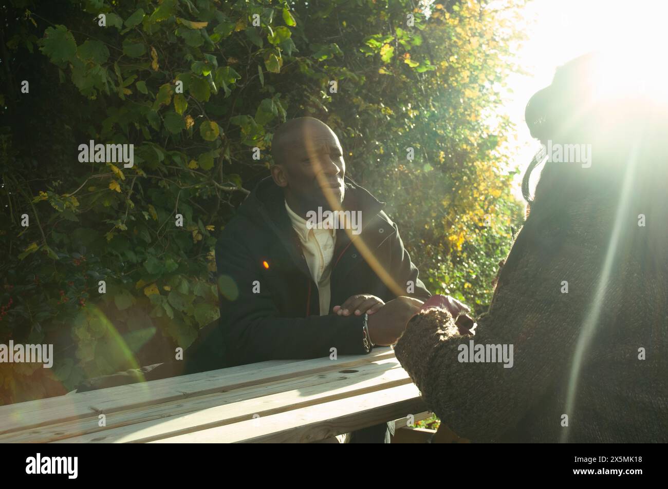 Couple talking at picnic table in park in autumn Stock Photo - Alamy