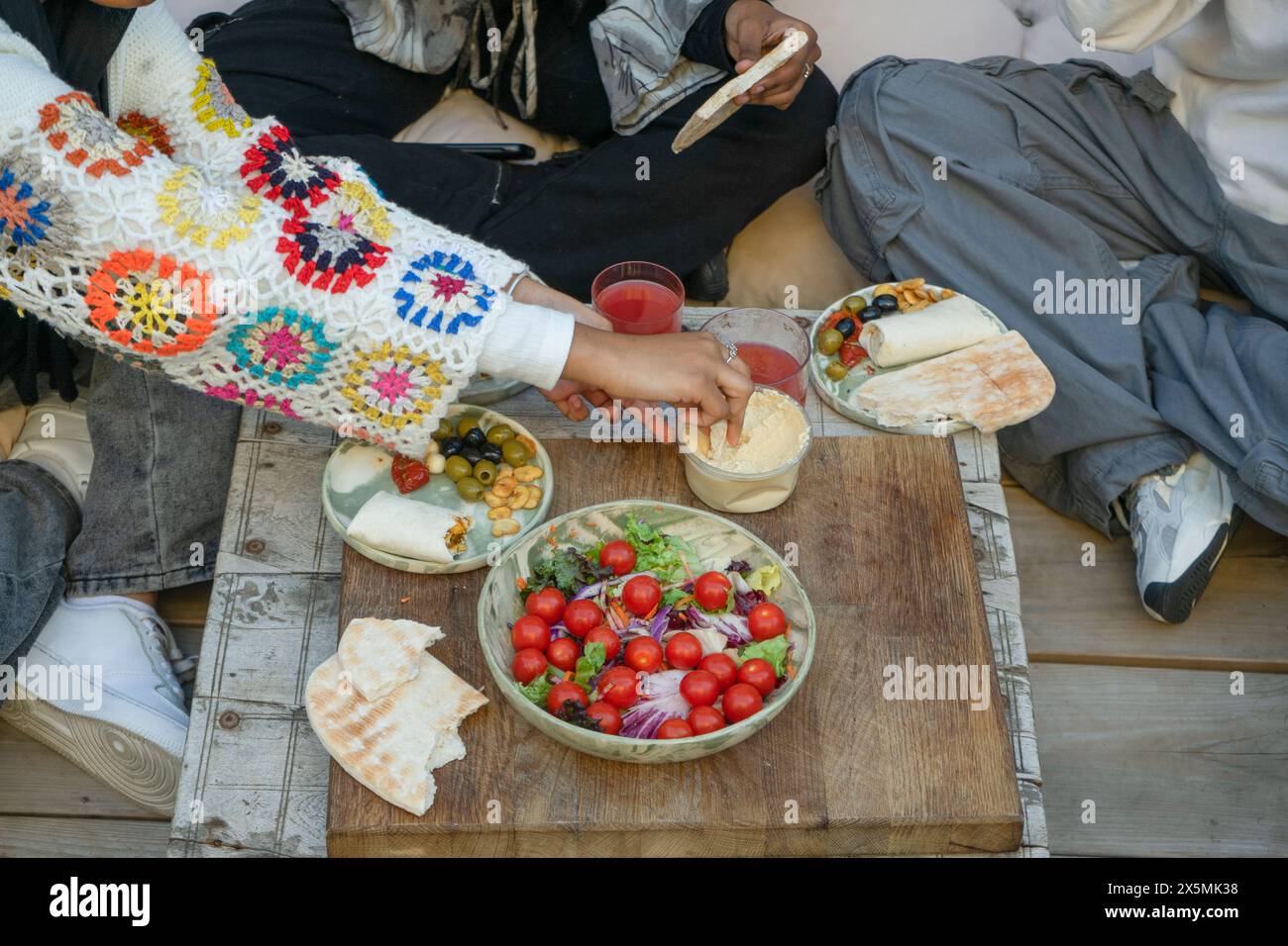 Friends sharing snacks on patio Stock Photo - Alamy