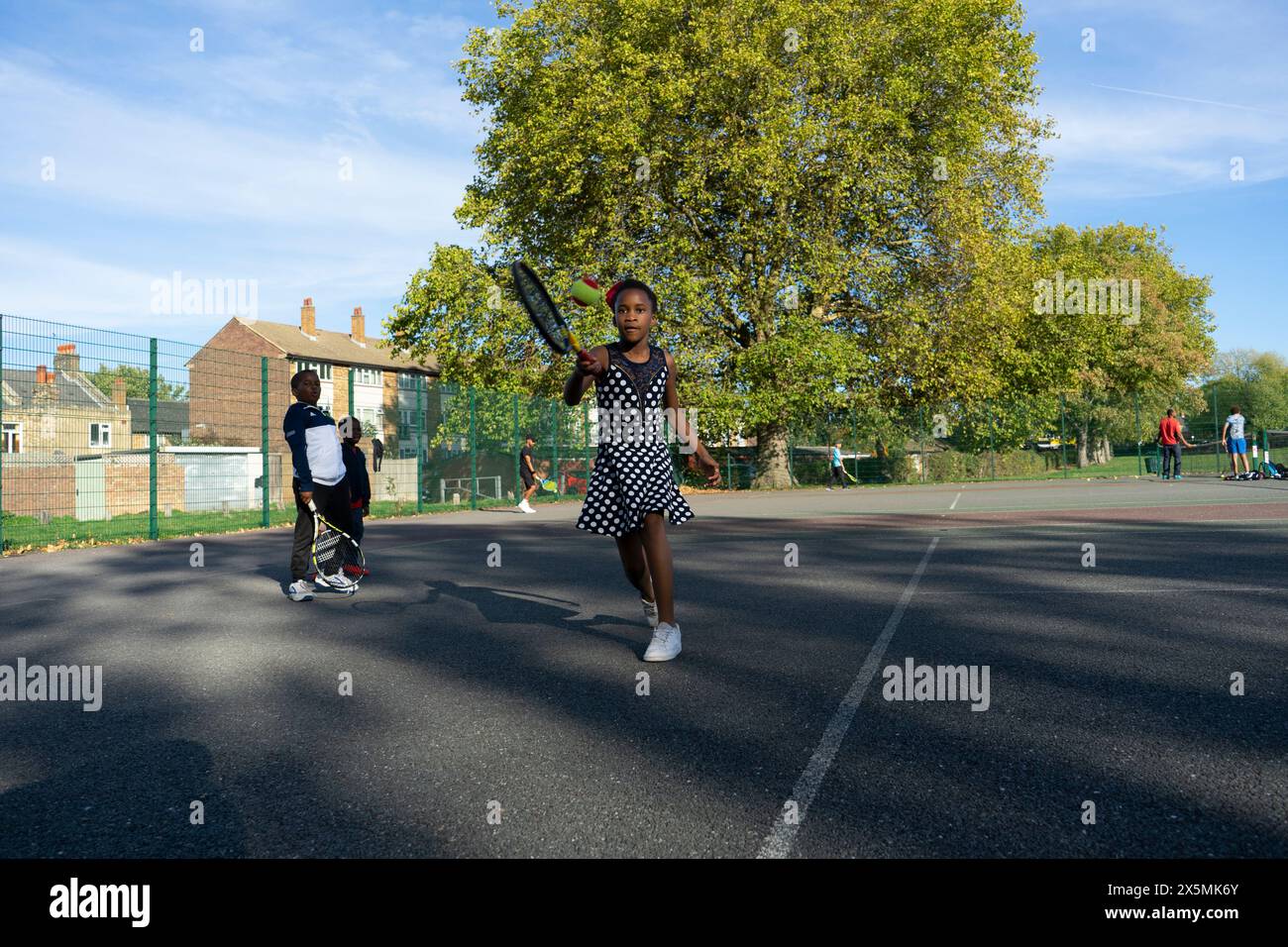 Children playing tennis on neighborhood court Stock Photo - Alamy