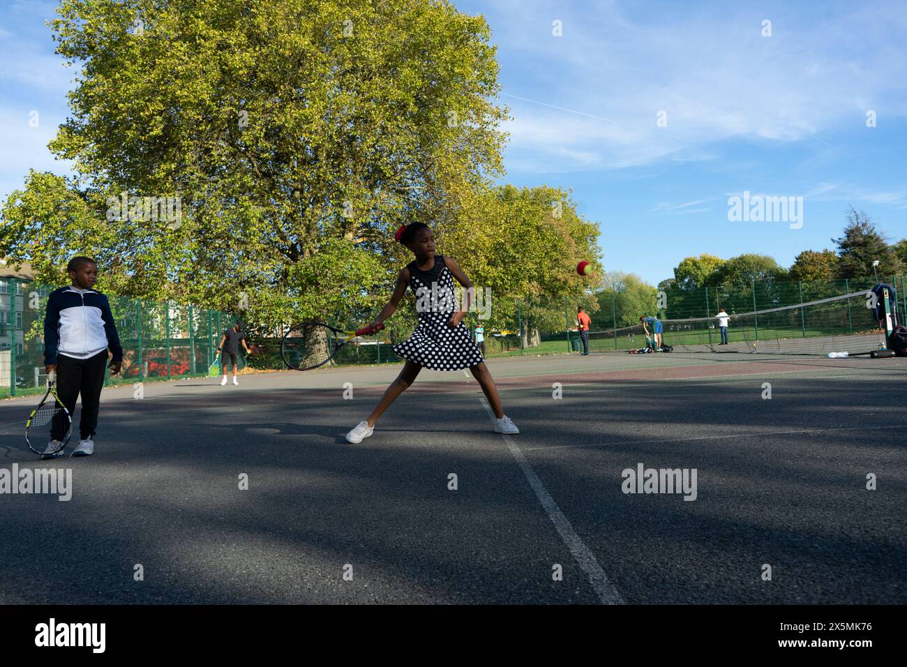 Children playing tennis on neighborhood court Stock Photo - Alamy