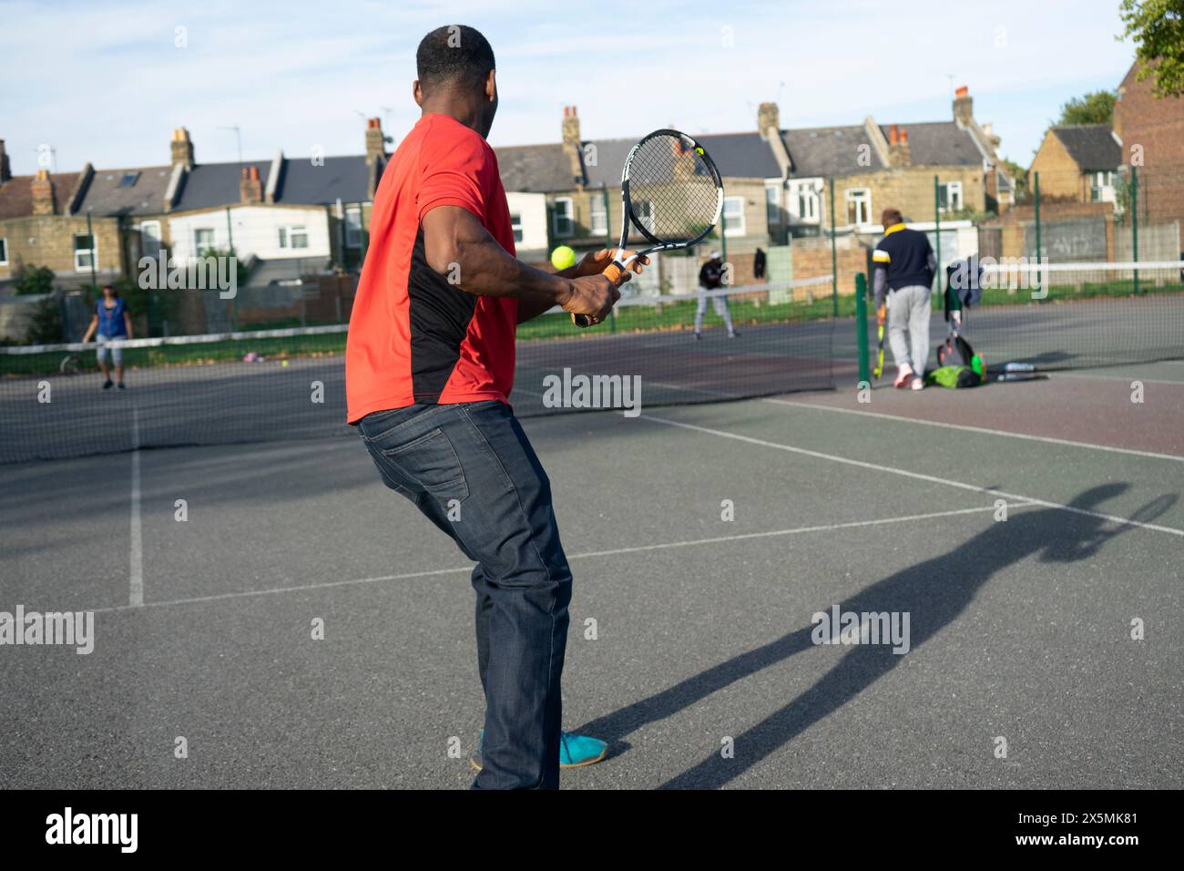 People playing tennis on neighborhood court Stock Photo - Alamy