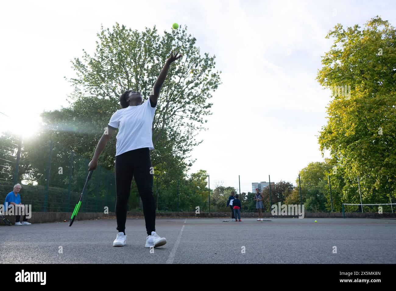 People playing tennis on neighborhood court Stock Photo - Alamy
