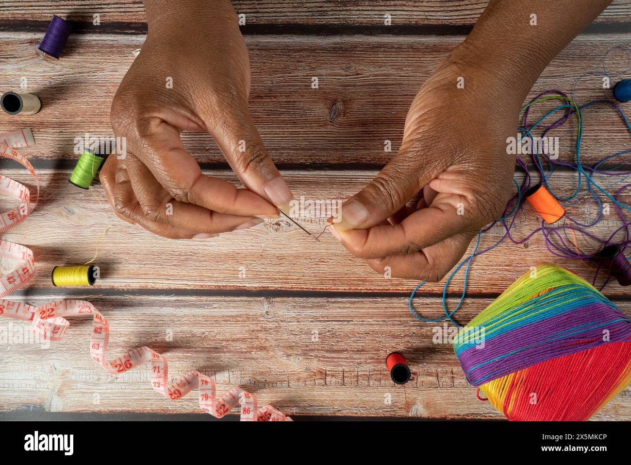 Woman threading a needle Stock Photo - Alamy