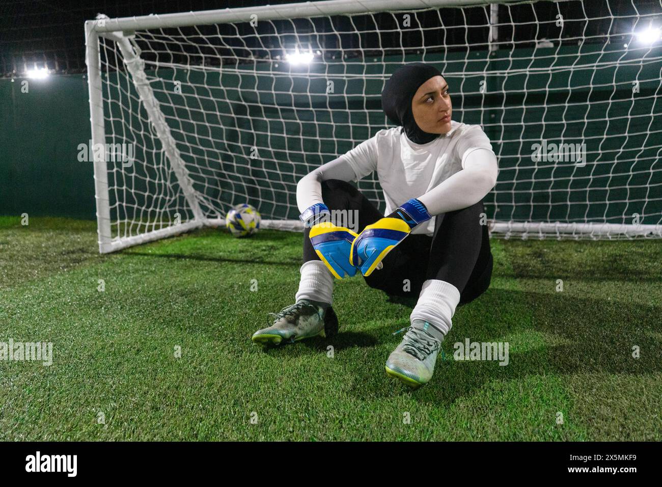Female goal keeper sitting on ground Stock Photo - Alamy