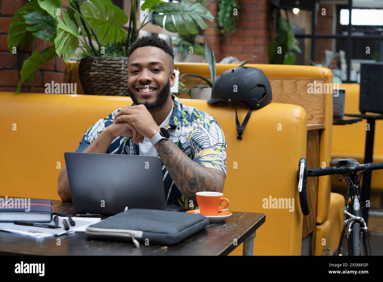 Portrait of man sitting in office lounge Stock Photo - Alamy
