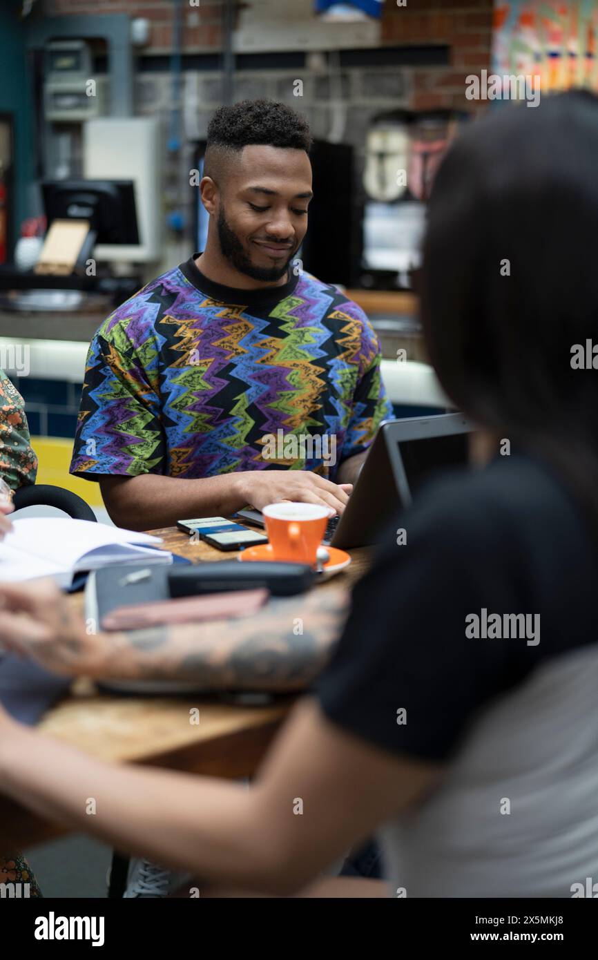 Creative professionals working together in cafeteria Stock Photo - Alamy
