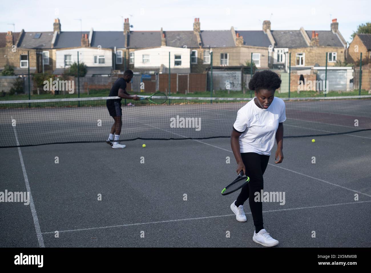 People playing tennis on neighborhood court Stock Photo - Alamy