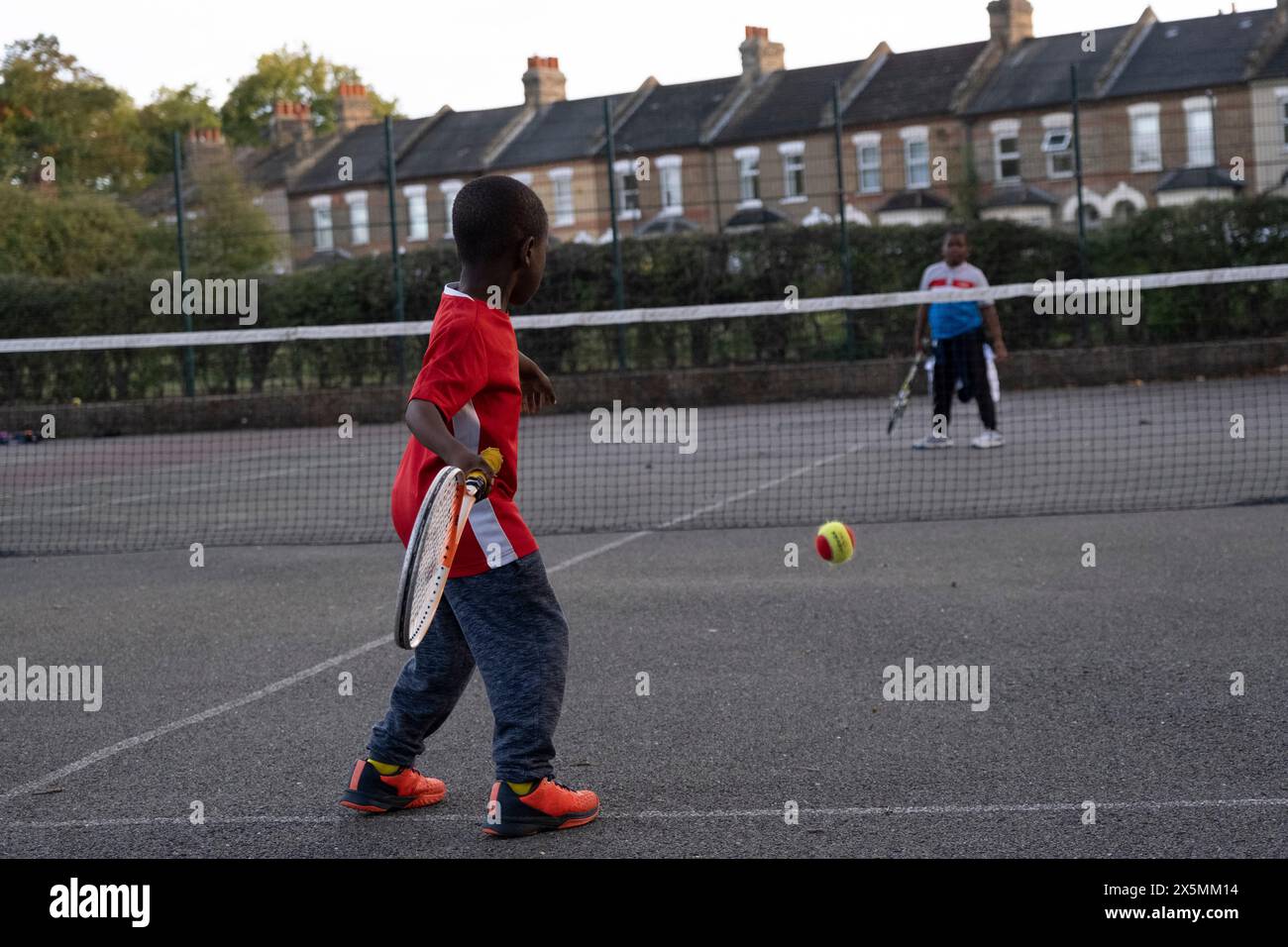 Children playing tennis on neighborhood court Stock Photo - Alamy