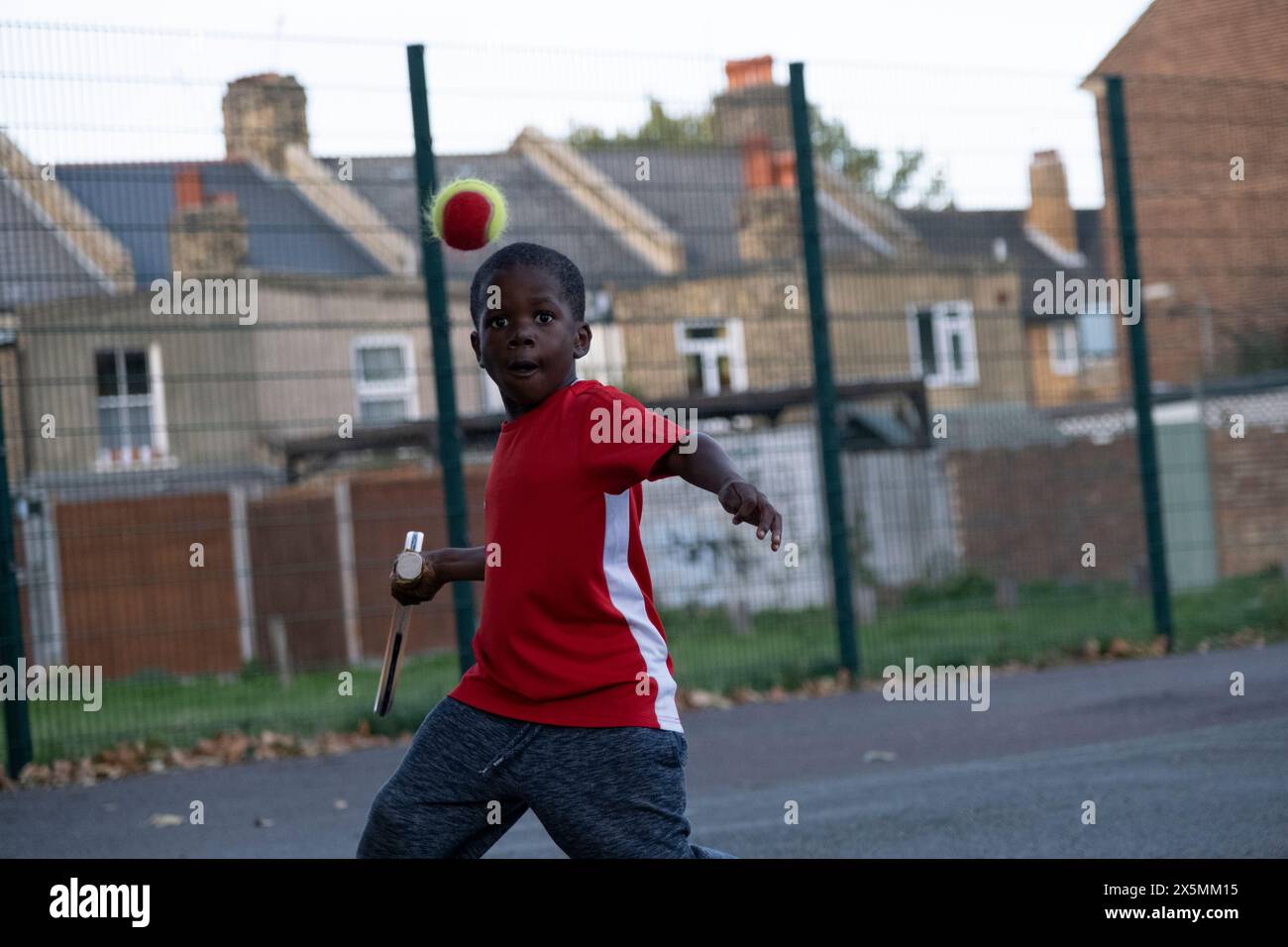 Boy playing tennis on neighborhood court Stock Photo - Alamy