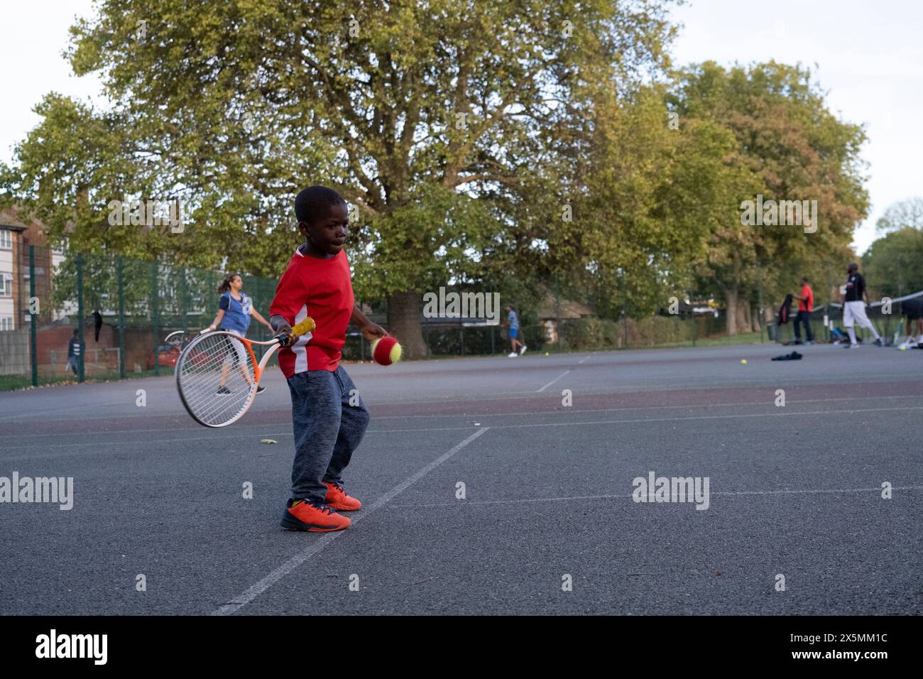Children playing tennis on neighborhood court Stock Photo - Alamy
