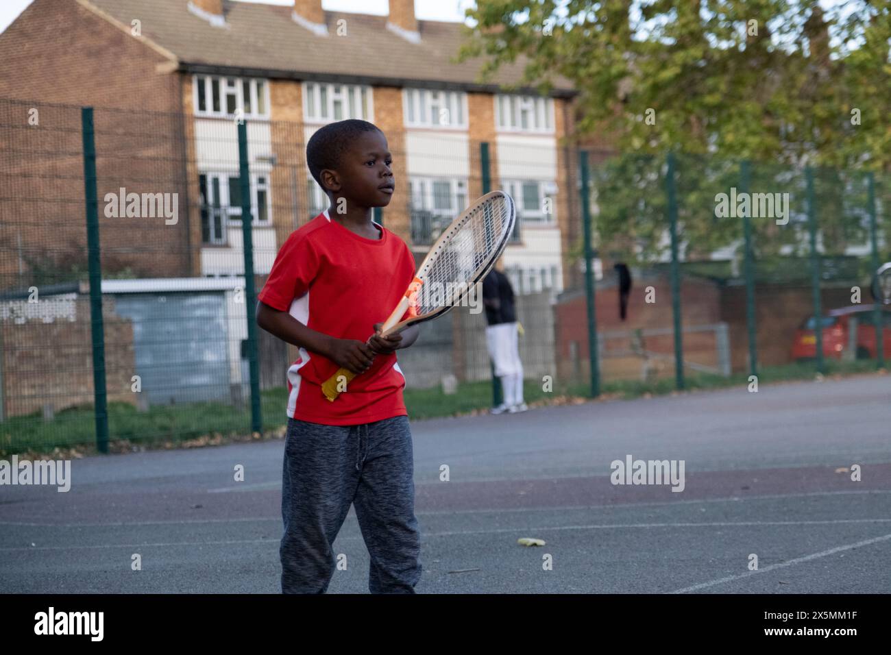 Boy playing tennis on neighborhood court Stock Photo - Alamy