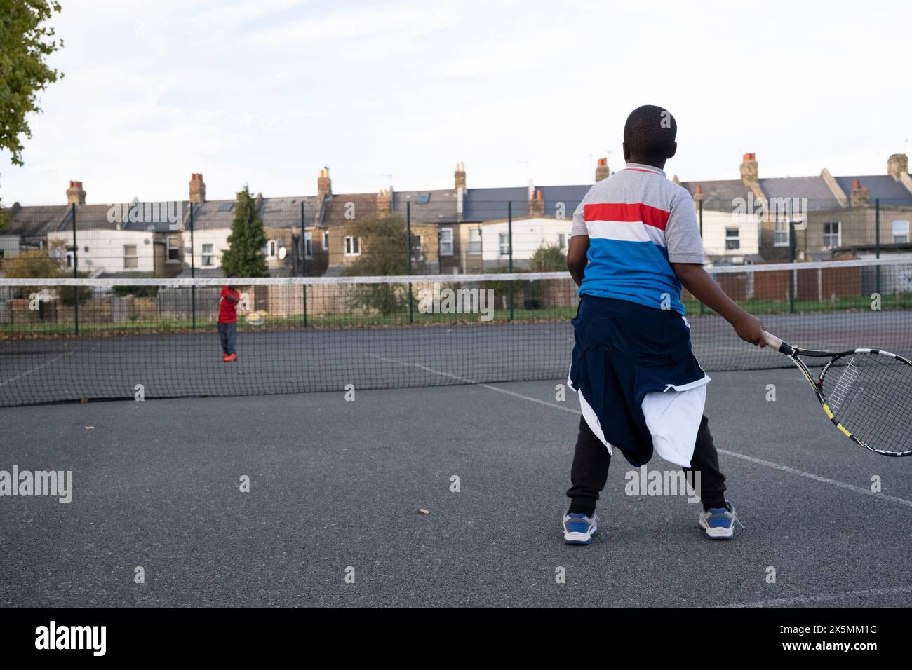 Children playing tennis on neighborhood court Stock Photo - Alamy