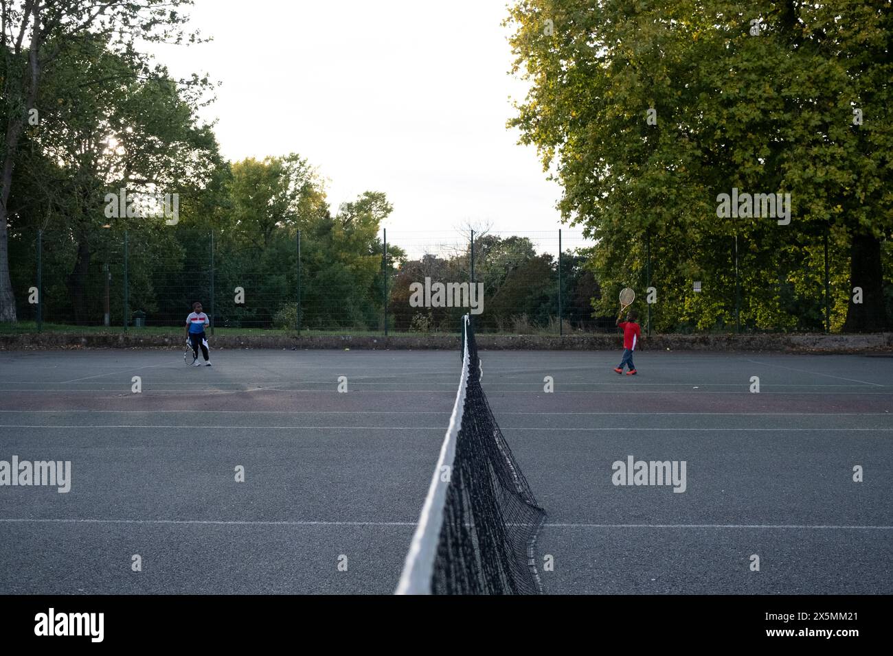 Children playing tennis on neighborhood court Stock Photo - Alamy