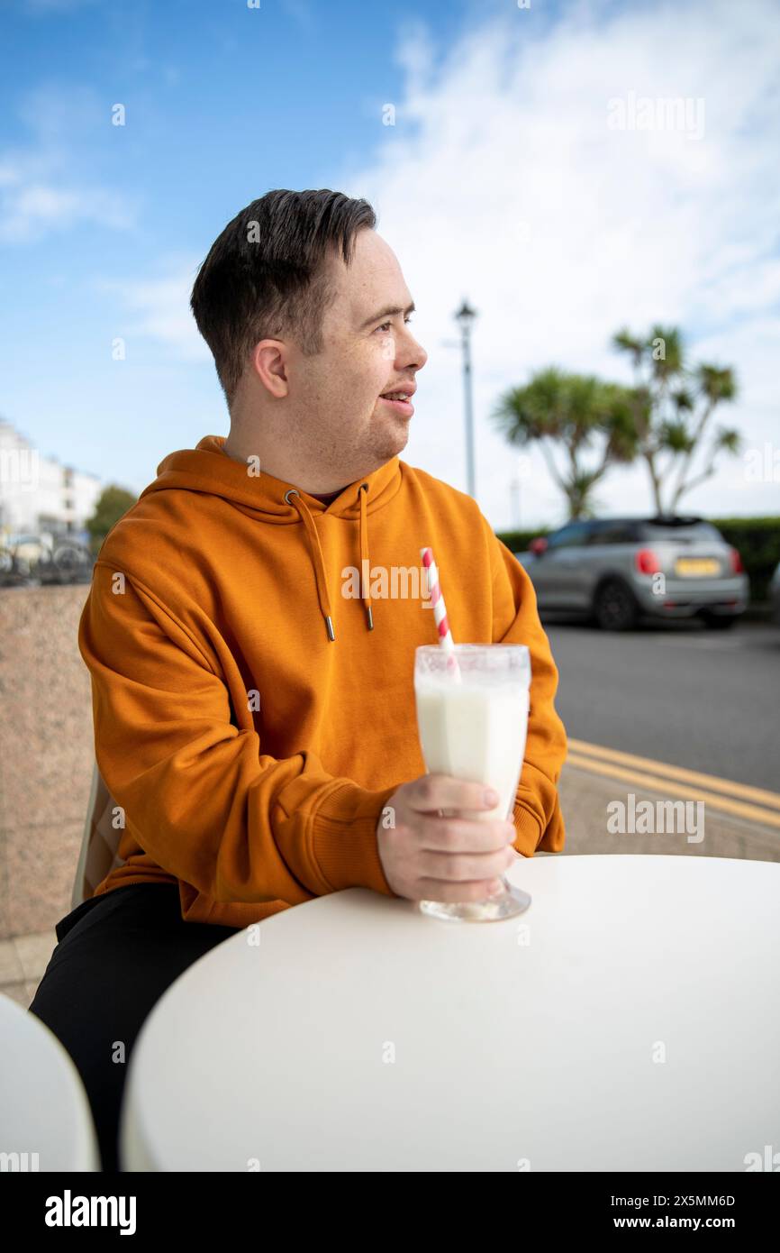 Man drinking milkshake in sidewalk cafe Stock Photo - Alamy