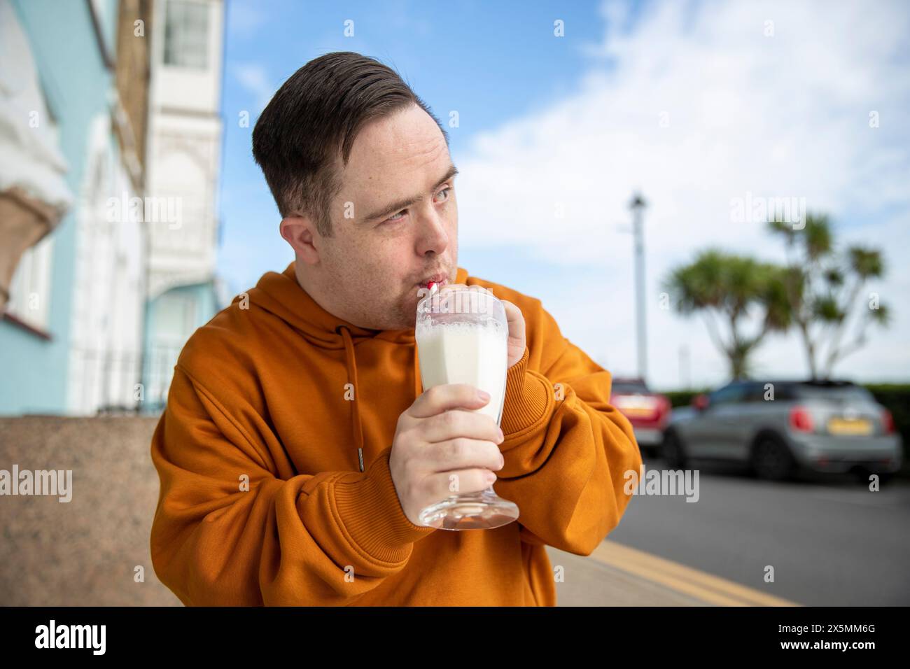 Man drinking milkshake in sidewalk cafe Stock Photo - Alamy