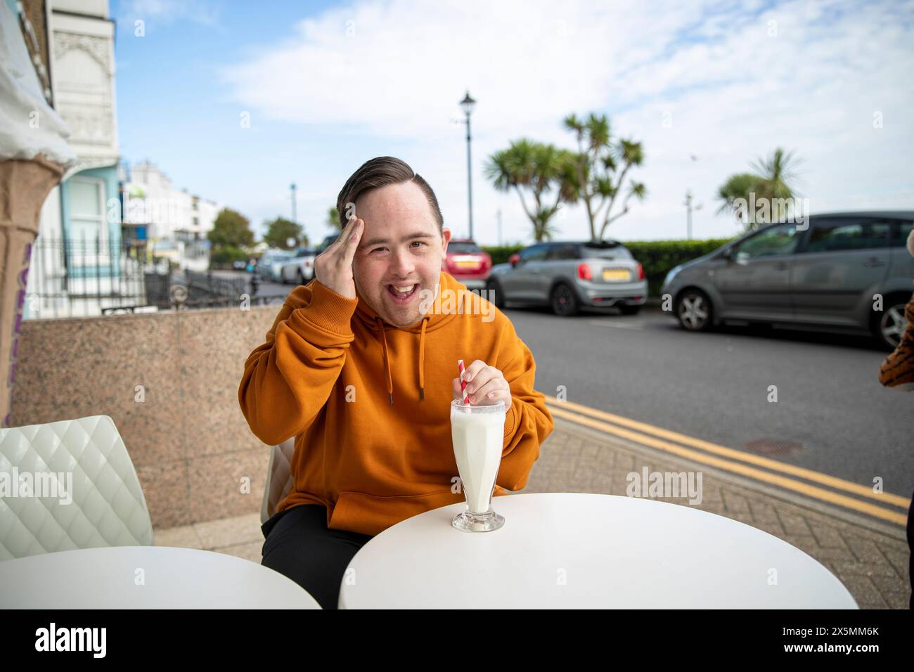 Man drinking milkshake in sidewalk cafe, portrait Stock Photo - Alamy