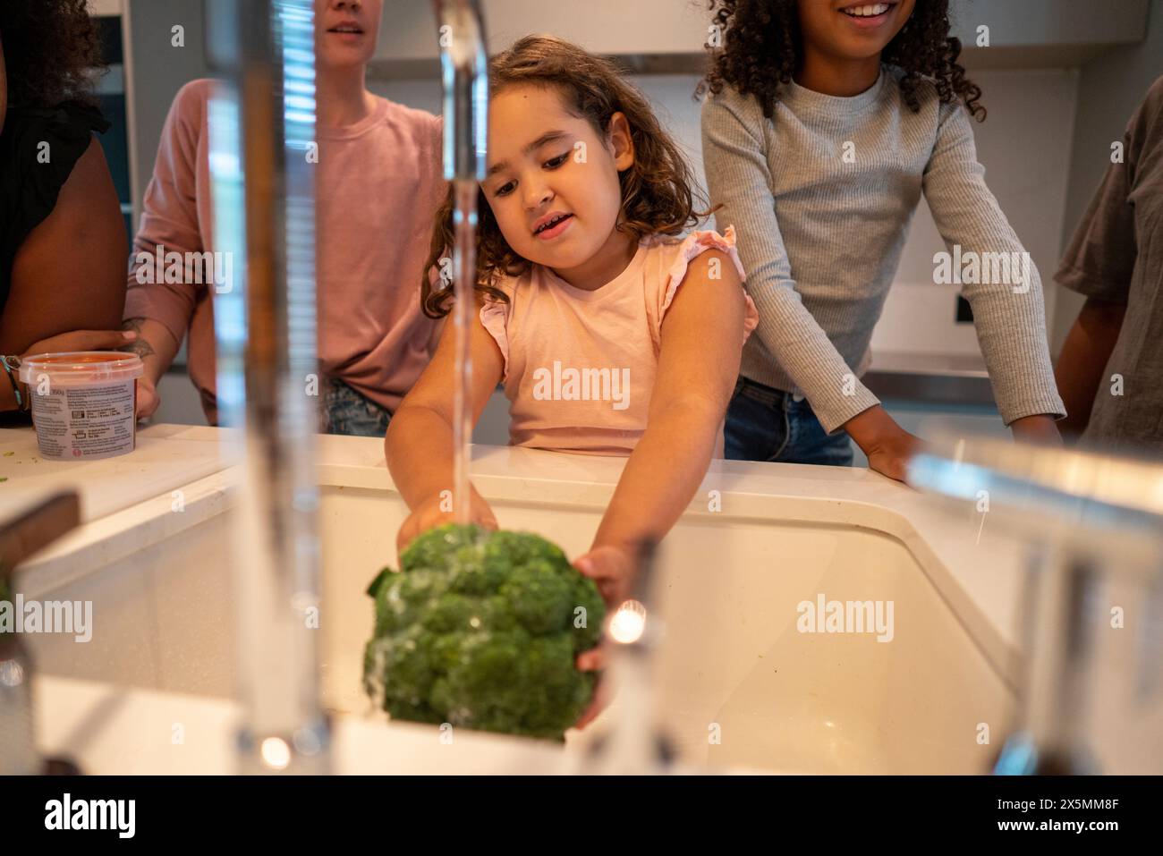 Girl washing broccoli in kitchen sink Stock Photo - Alamy