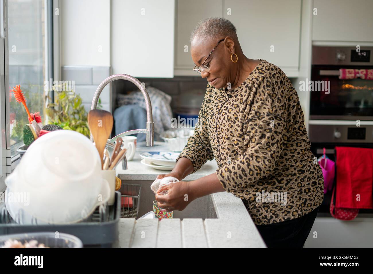 Woman washing dishes in kitchen Stock Photo - Alamy