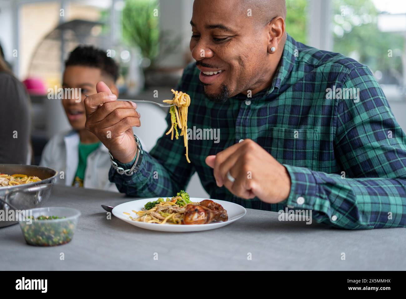Man eating dinner with family Stock Photo - Alamy