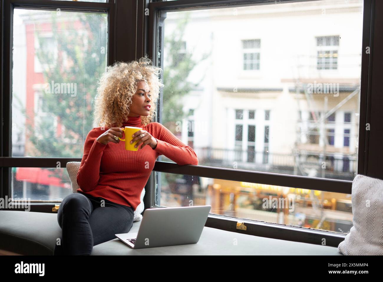 Woman looking through office window Stock Photo - Alamy