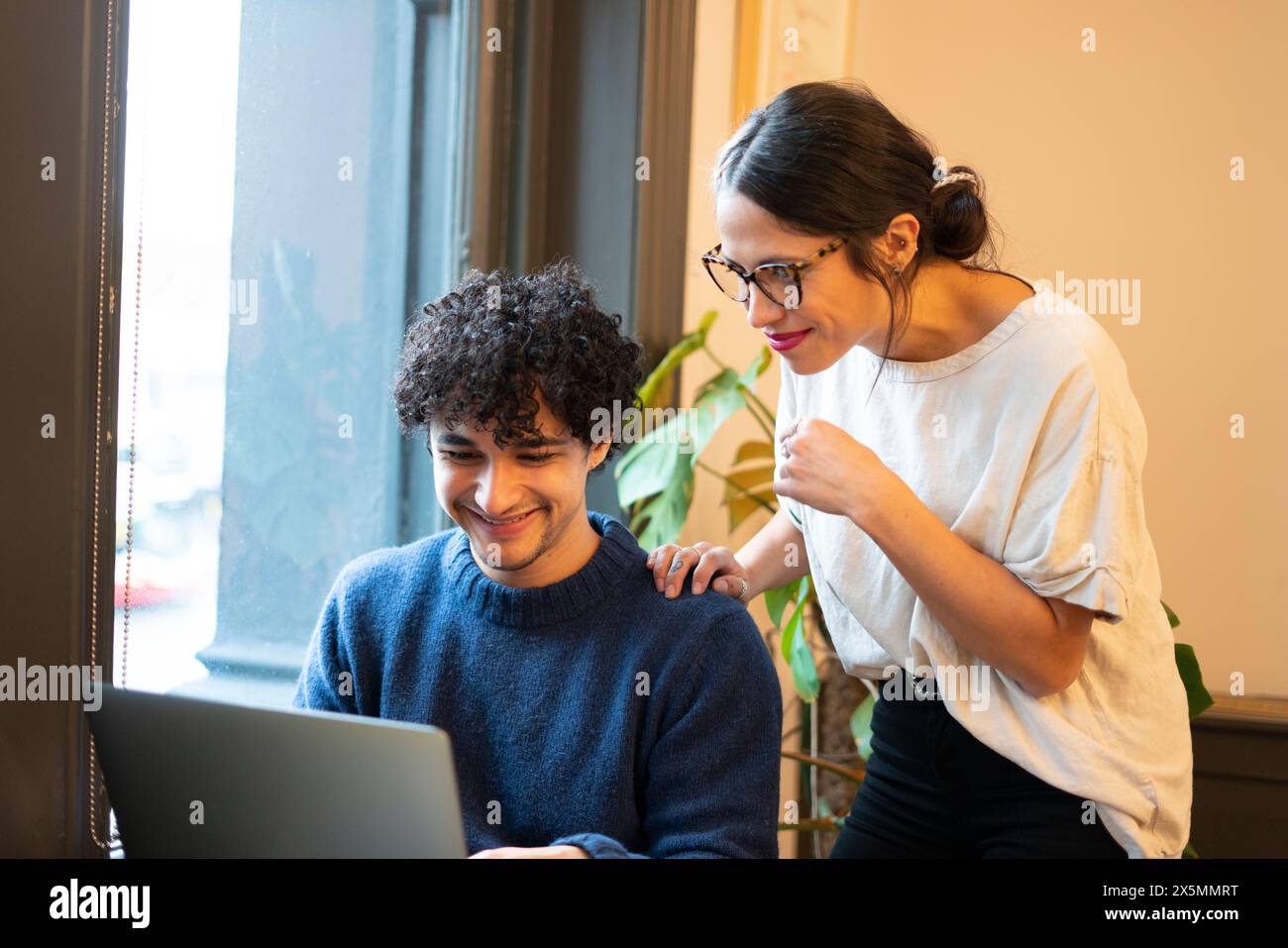 Man and woman using laptop in office Stock Photo - Alamy