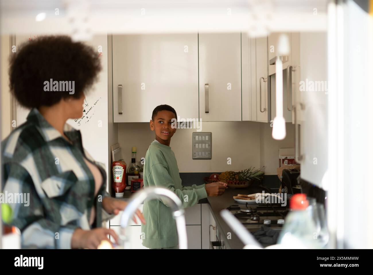 Mother and son washing dishes and cooking in kitchen Stock Photo - Alamy