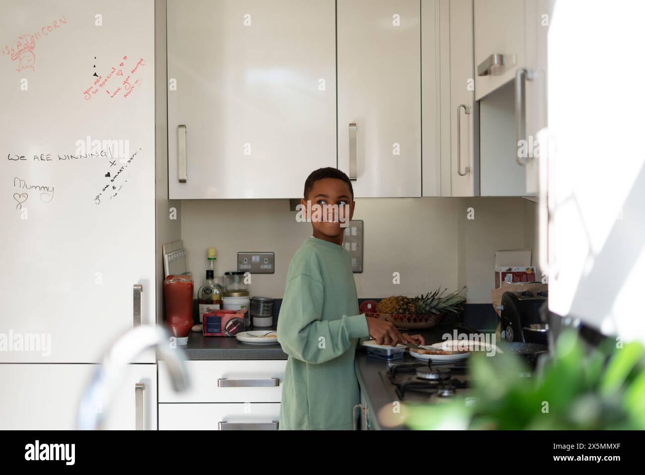 Smiling boy cooking in kitchen Stock Photo - Alamy