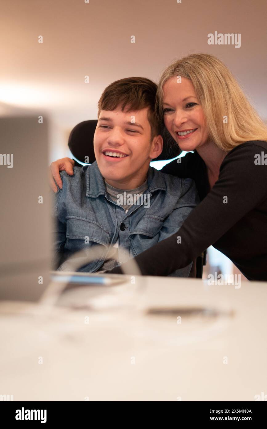 Mother and disabled son using laptop Stock Photo - Alamy