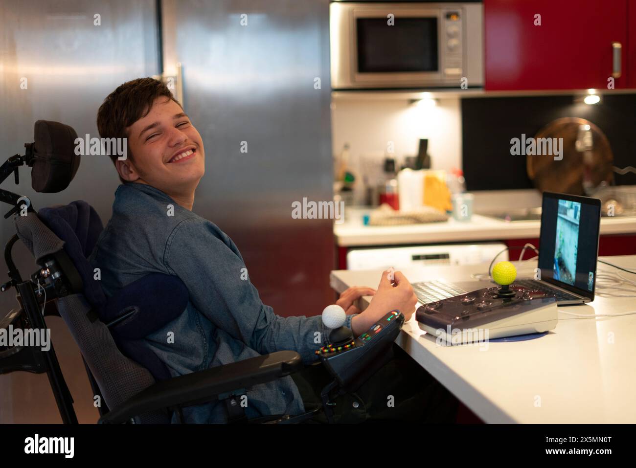 Portrait of disabled teenage boy using laptop Stock Photo - Alamy