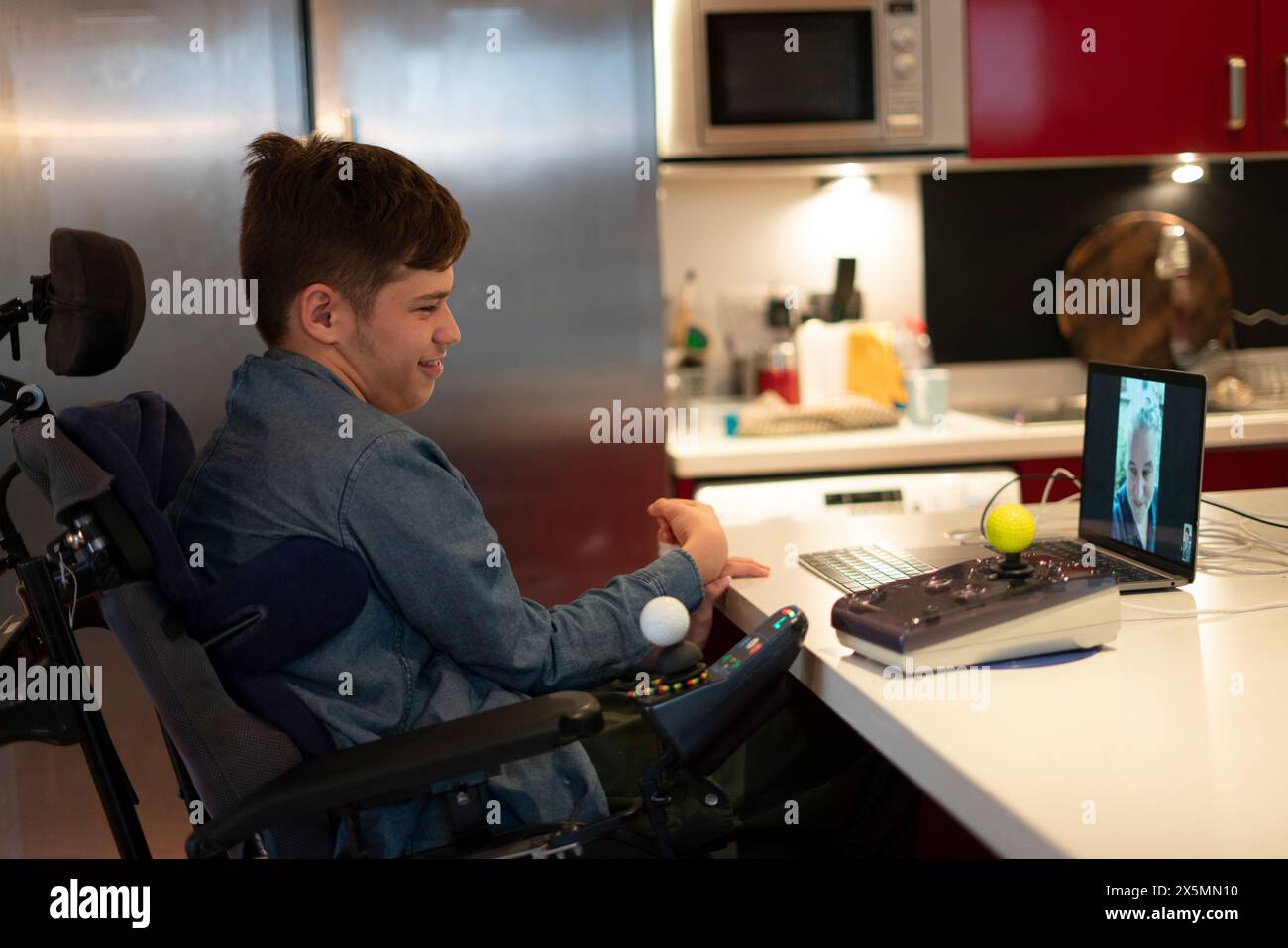 Disabled son talking with father on laptop through video call Stock ...