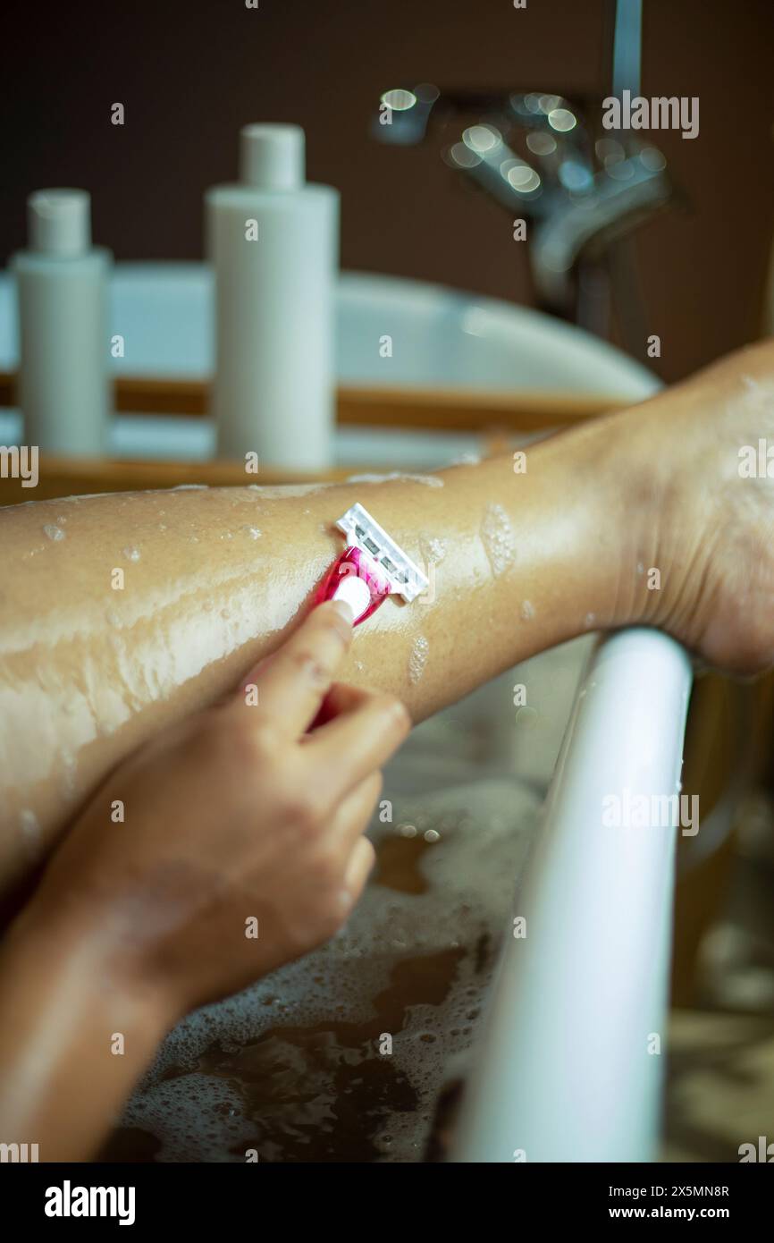 Close-up of woman shaving leg in bathtub Stock Photo - Alamy