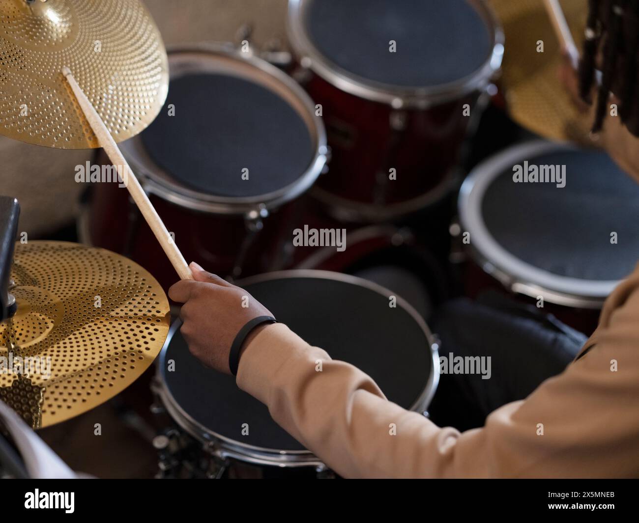 Teenage boy practicing playing drums Stock Photo - Alamy