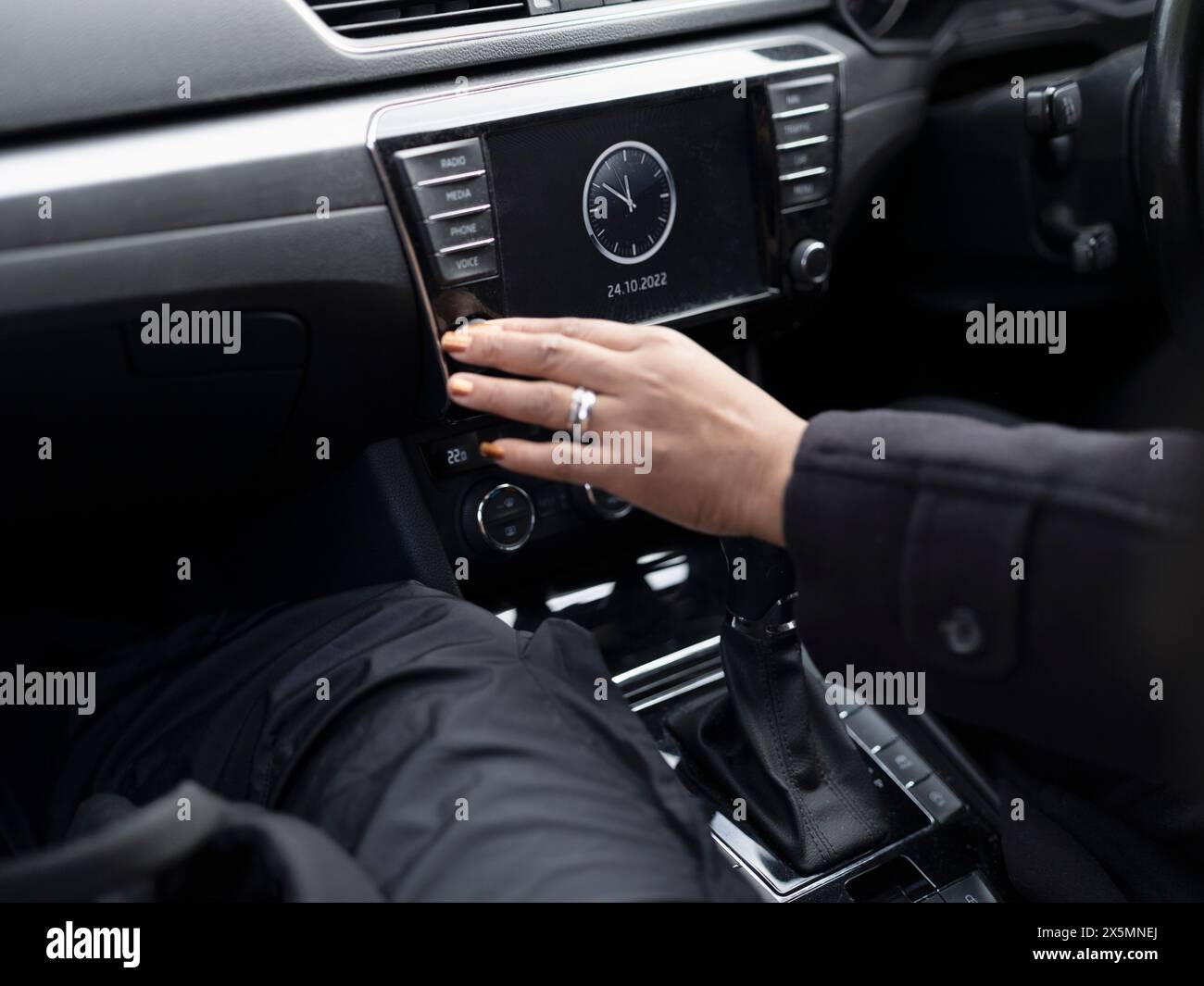 Woman using dashboard buttons in car Stock Photo - Alamy