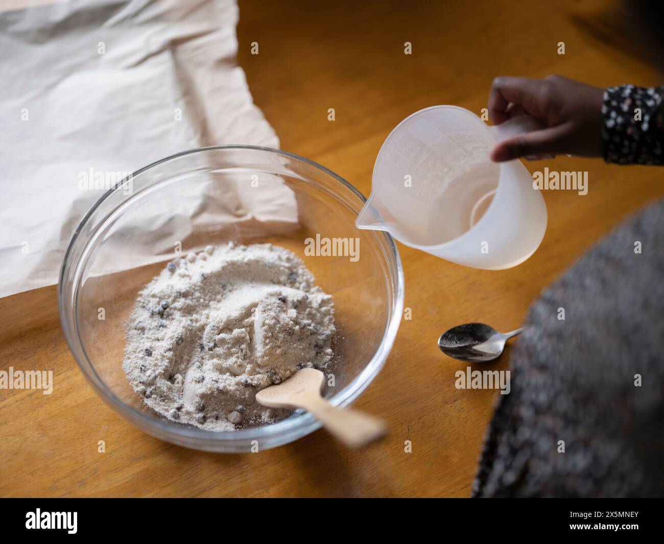 Girl pouring water into cookie mixture Stock Photo - Alamy